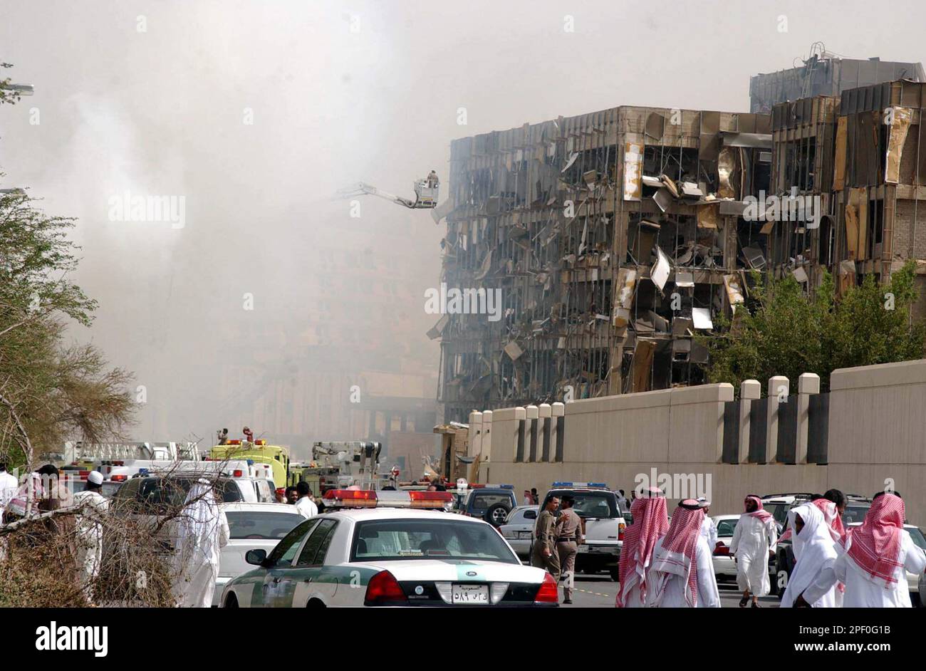 Saudis gather in front of the partially destroyed headquarters building ...