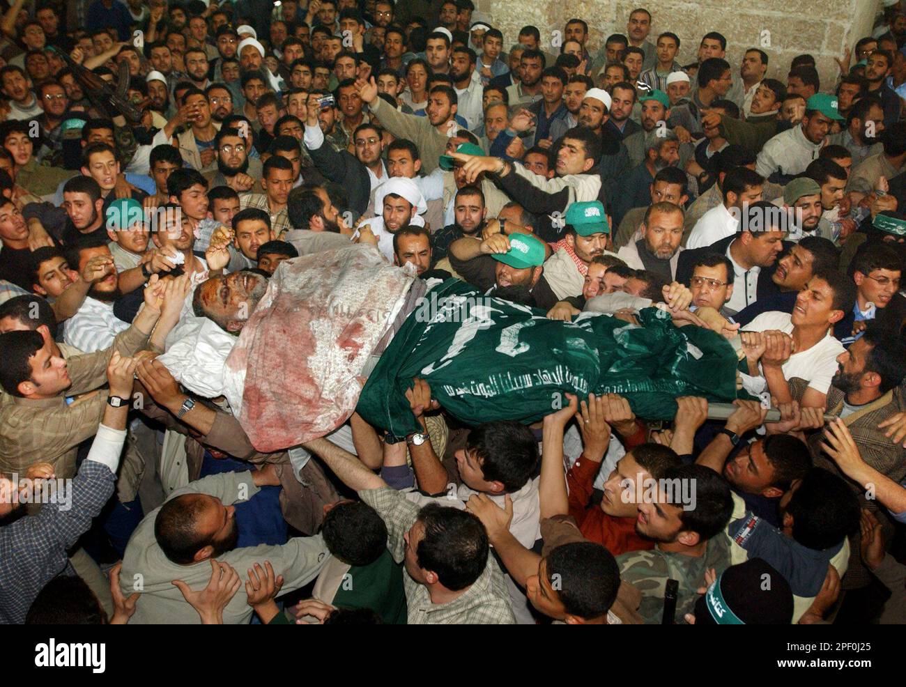 Palestinians reach to touch the body of the late Hamas leader Abdel ...