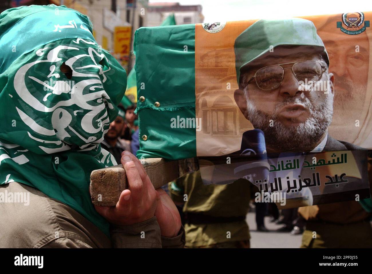 A Masked Palestinian Hamas activist, his face covered with a Hamas flag ...