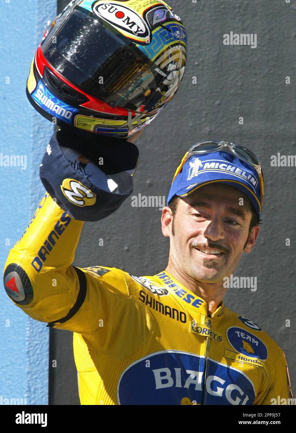 Italian Max Biaggi, holds up his helmet after winning second position ...
