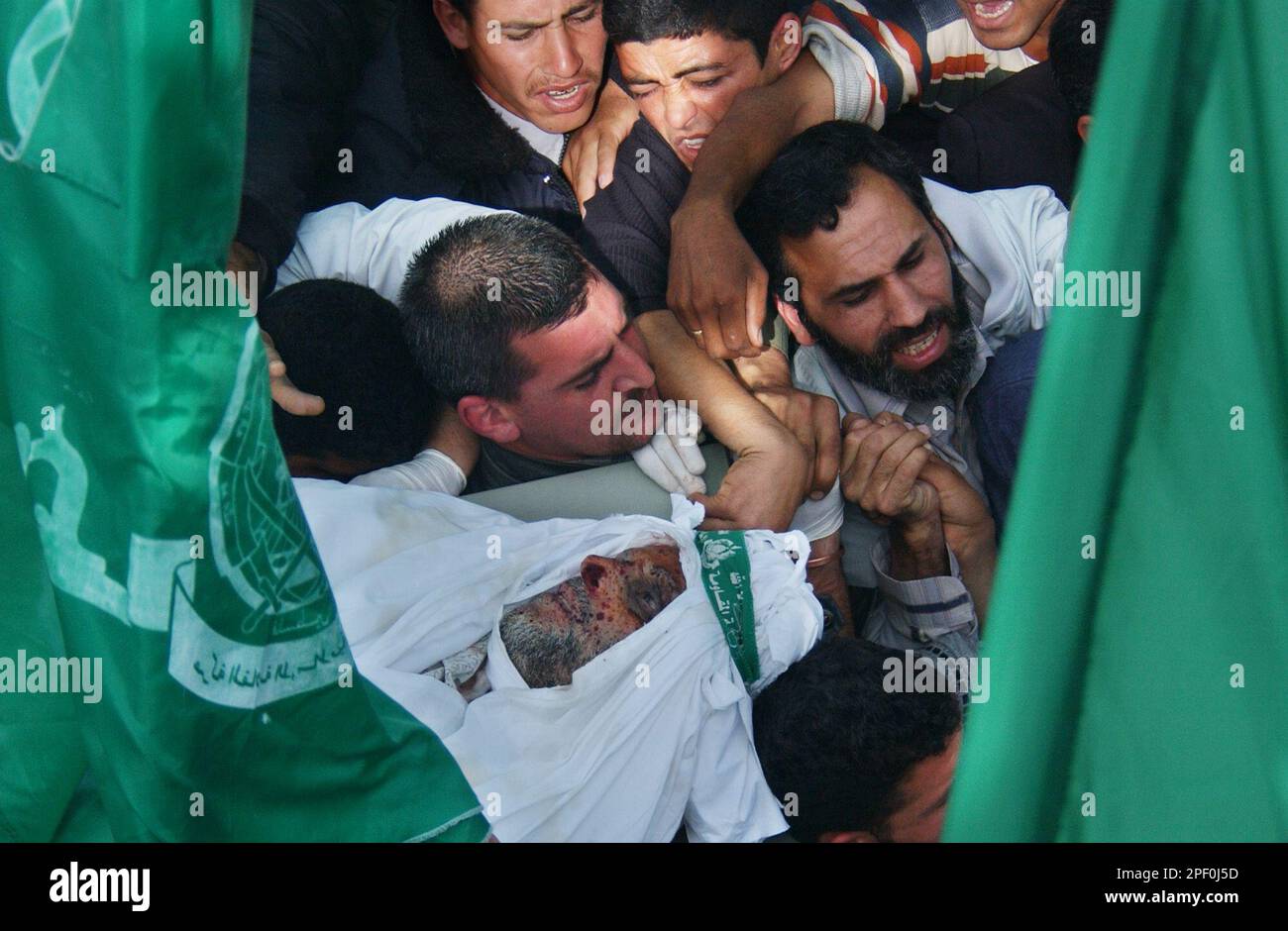 Palestinians reach to touch the body of the late Hamas leader Abdel ...