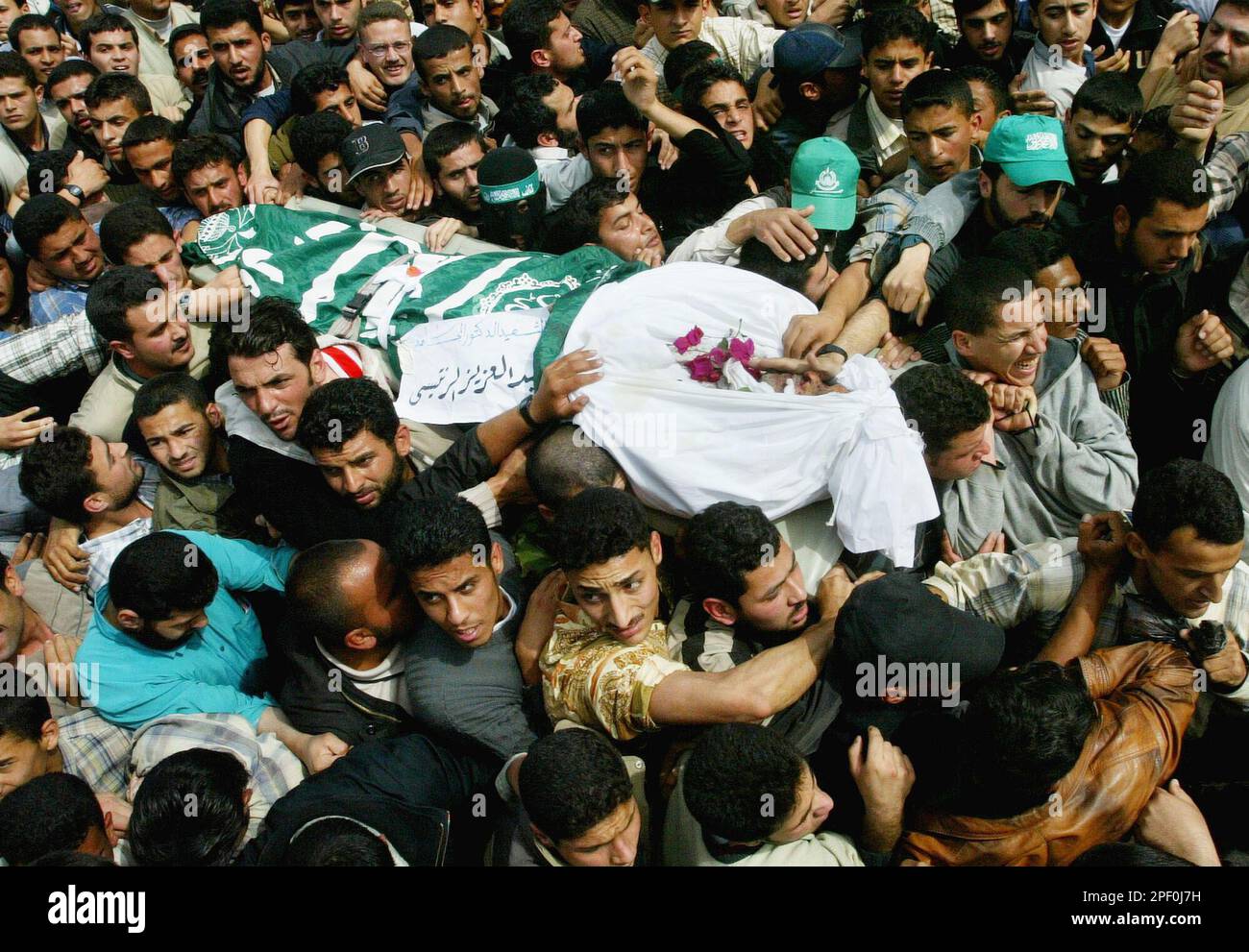 Palestinians reach to touch the body of the late Hamas leader Dr. Abdel ...