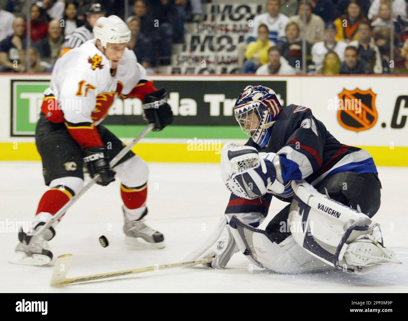 Vancouver Canucks goalie Alex Auld, right, stops Calgary Flames Chris ...