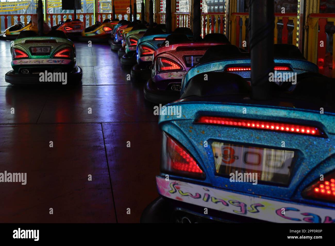 Dodgem cars parked in a line with their lights glowing Stock Photo - Alamy