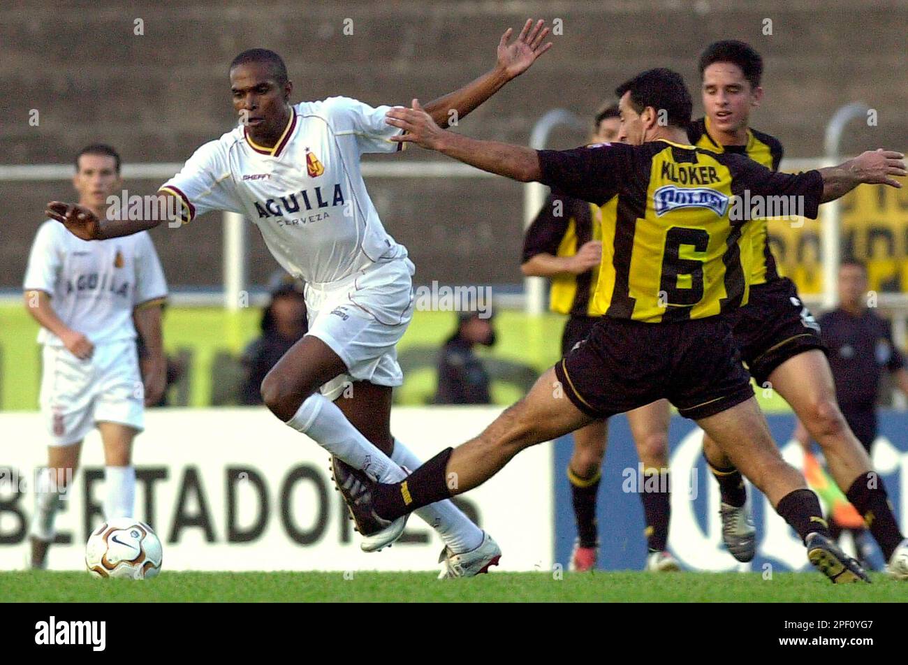 Rene Klocker of Venezuela's Tachira, right, trips Ivan Velazquez of ...