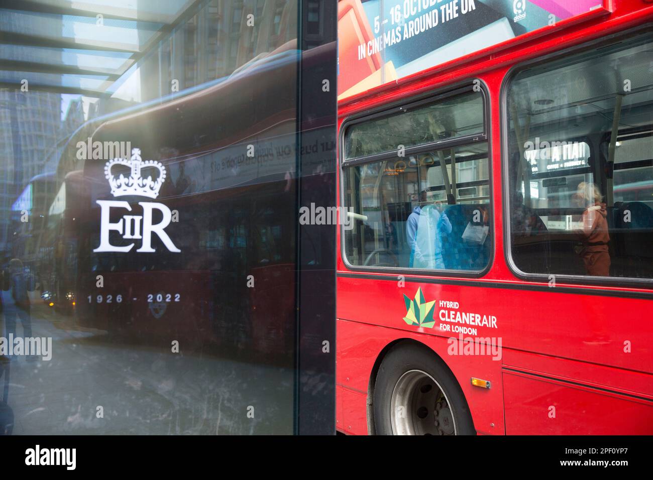People are reflected in a bus window as the royal cypher of the late ...