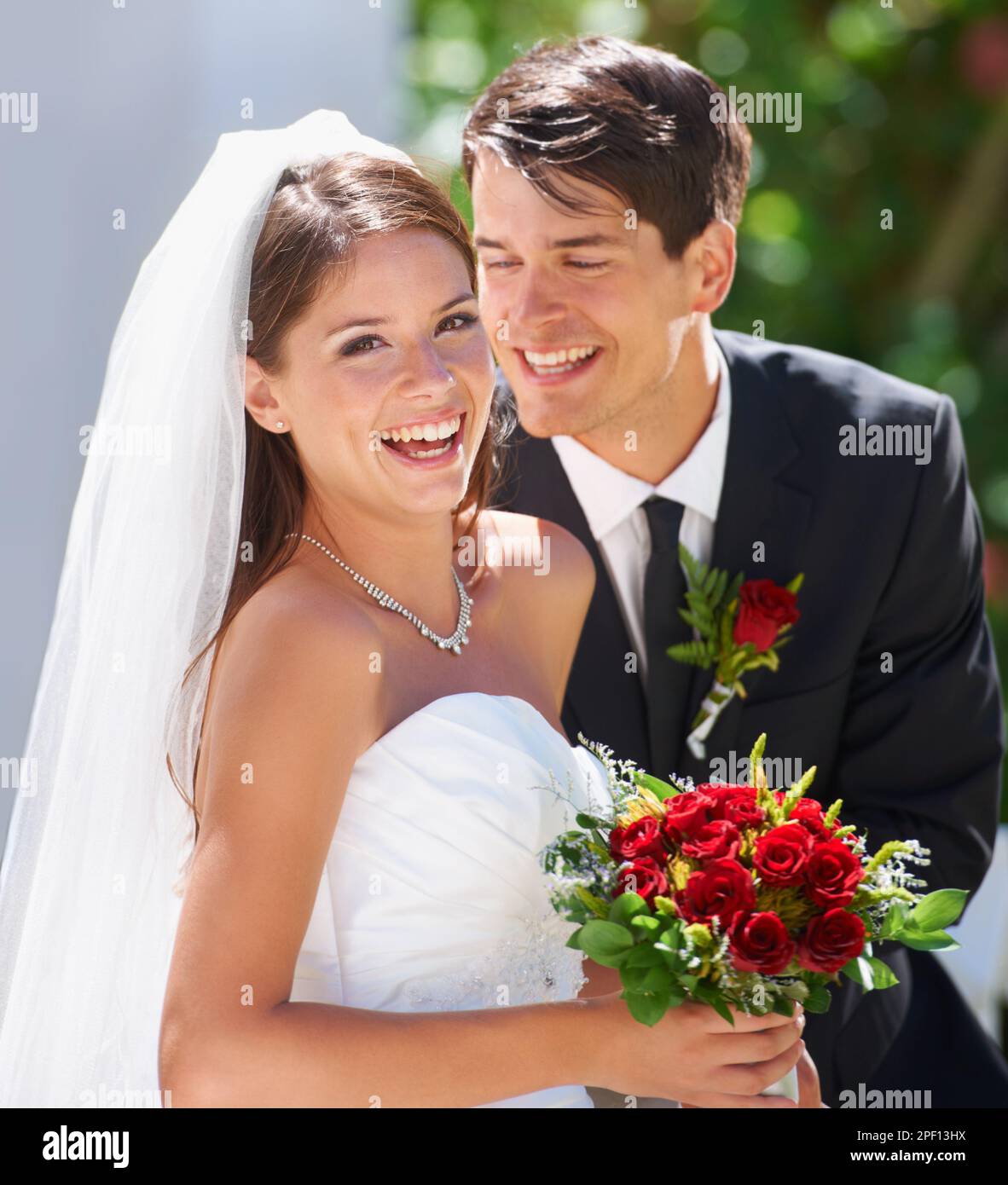 Whispering sweet nothings. Two delighted newlyweds celebrating outdoors ...