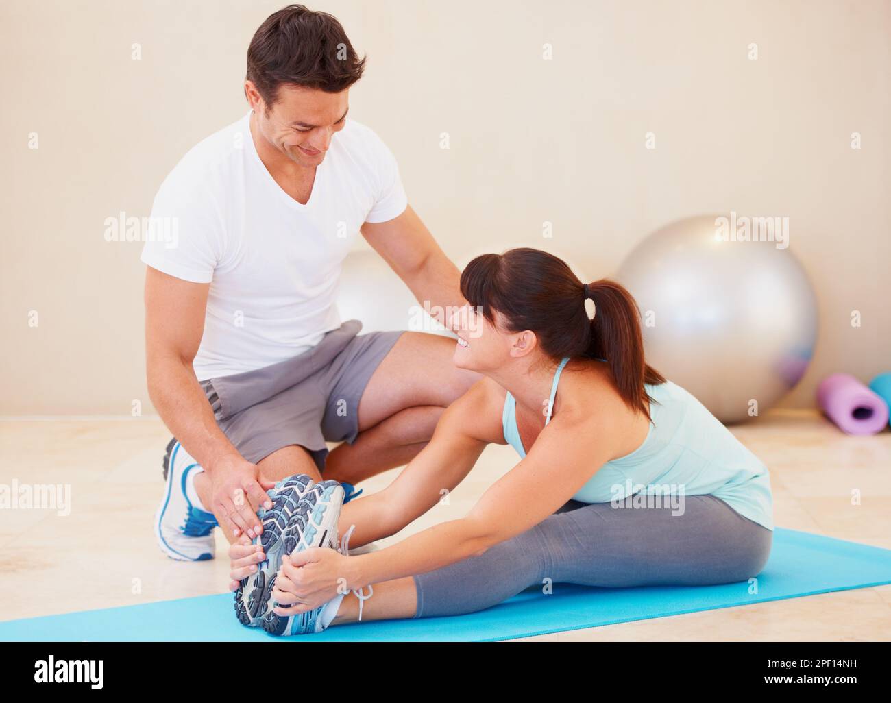 Giving great fitness advice. Young woman working out with the help of a ...