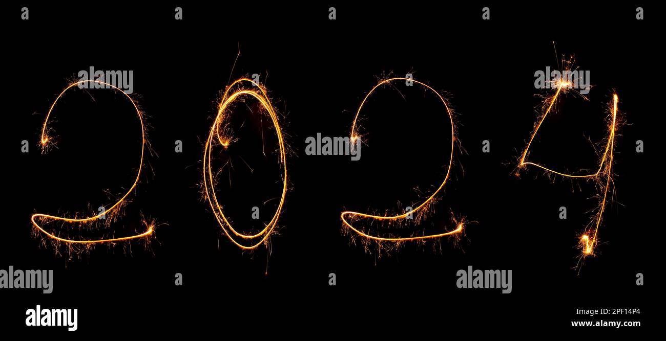 Year 2024 is written in numbers black background with sparklers with ...