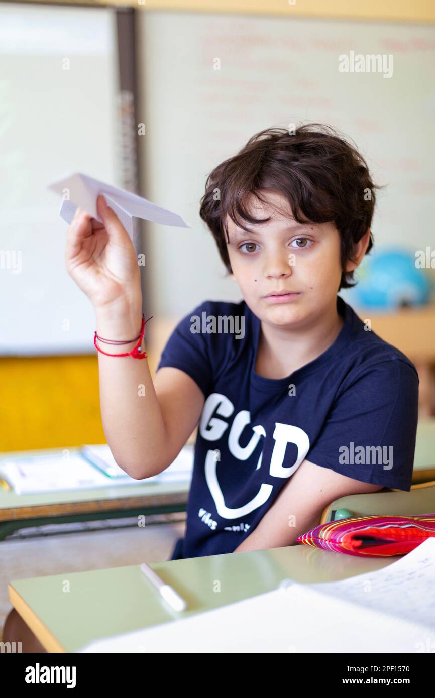 Portrait of young caucasian student playing with paper airplane in ...