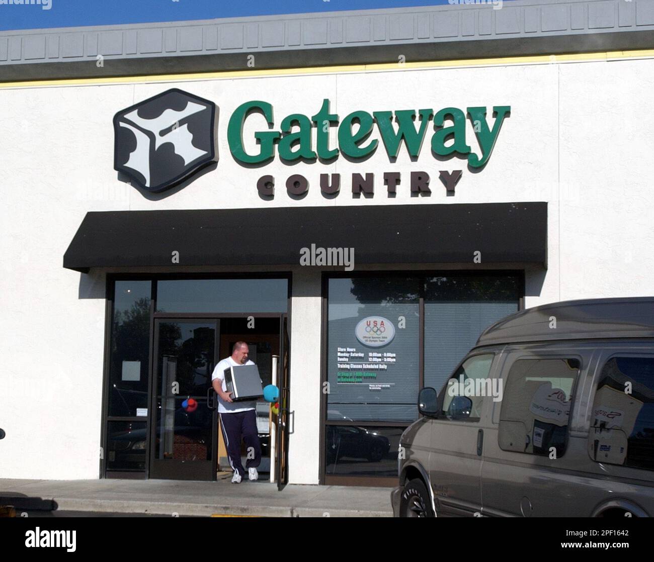 A man walks out of a Gateway Country store with a computer in San Jose ...