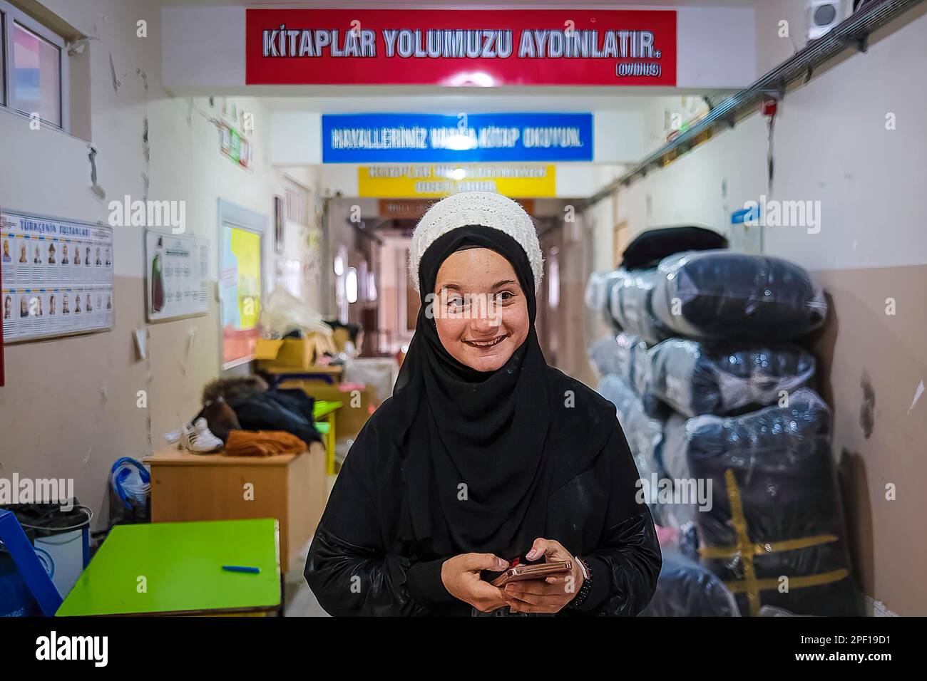 Muna poses in front of a sign reading "Books Light Up Our Way" written ...