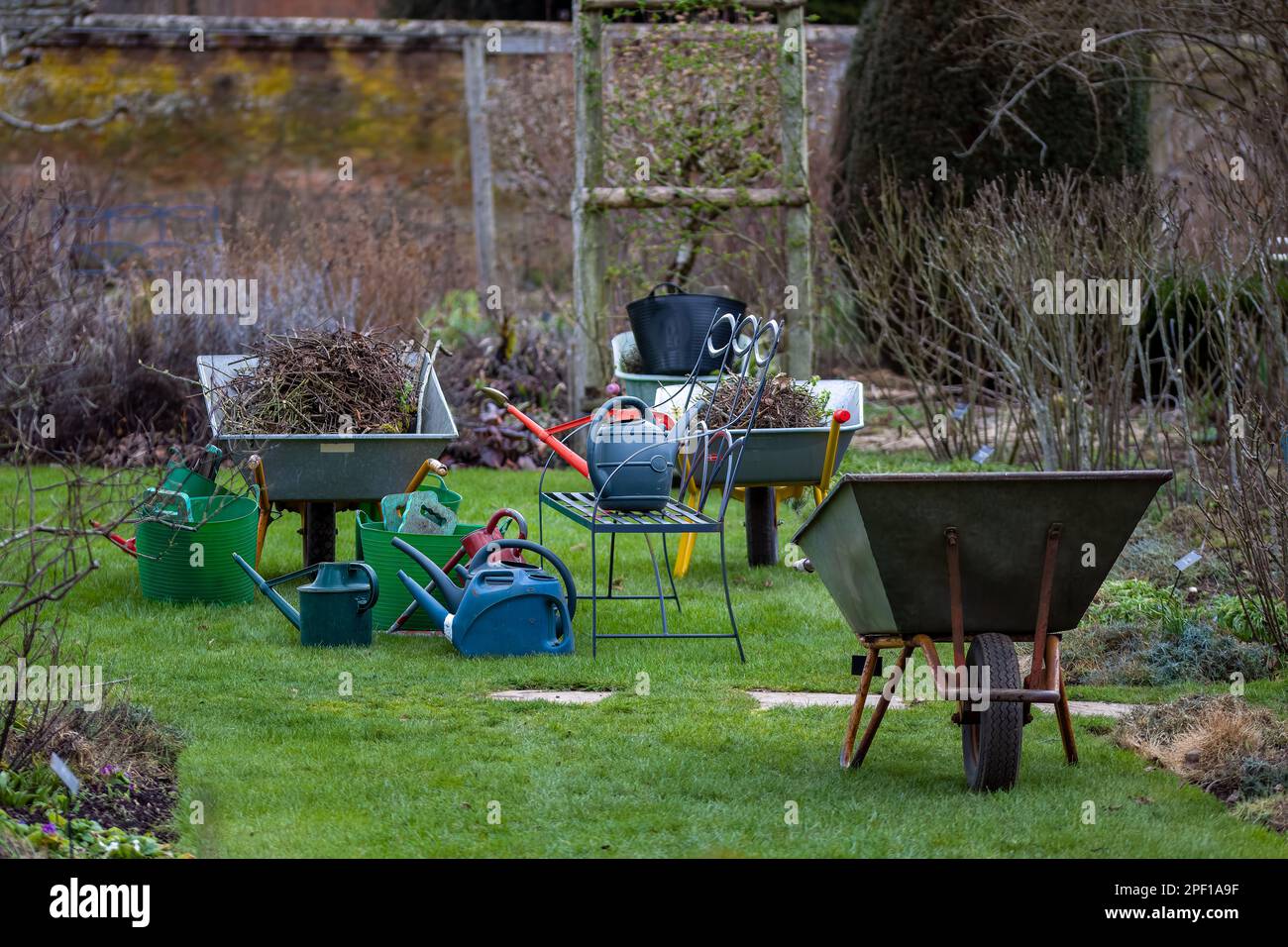 working scene gardening equipment wheelbarrows and watering cans in the garden in use getting ...