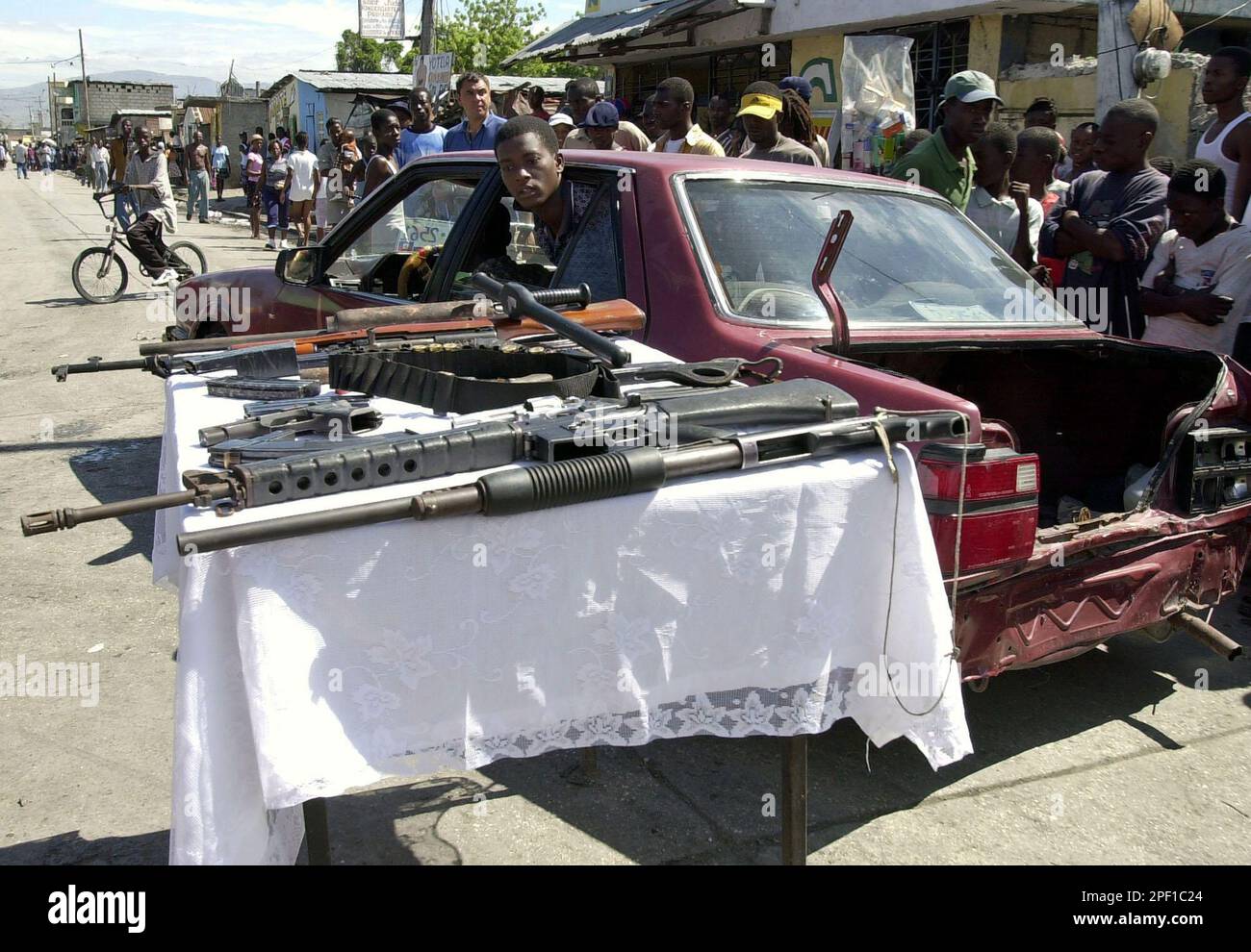 Locals look at weapons handed to authorities by residents in La Saline ...