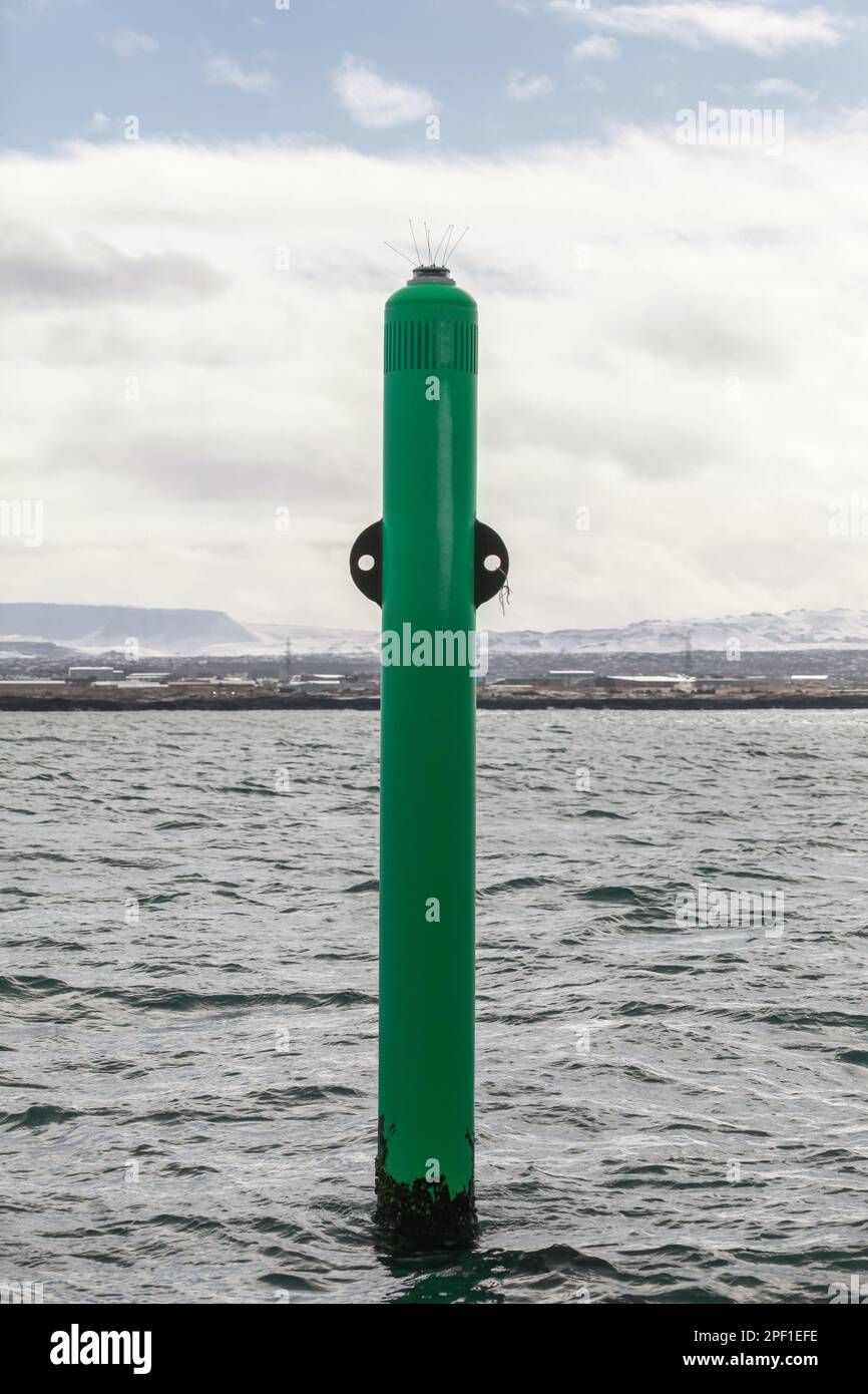 Starboard hand green spar buoy with light on top, close up vertical ...
