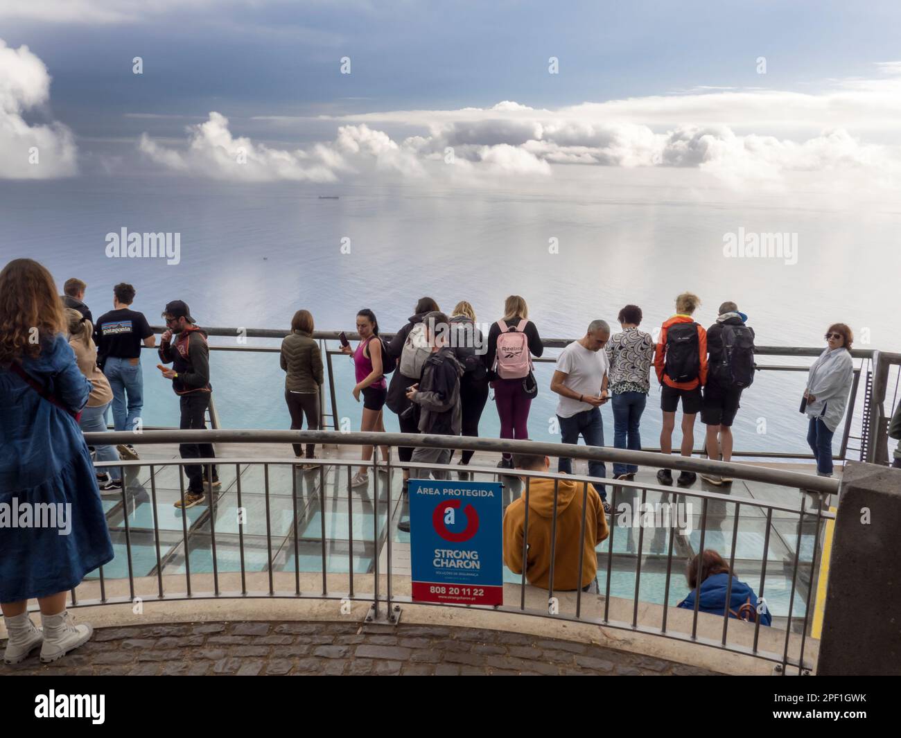 Tourists on a glass viewing platform above the steep sea cliffs on Cabo ...