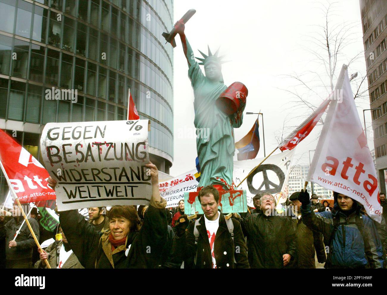 An Iraqi flag flies as demonstrators carry a mock Statue of Liberty ...
