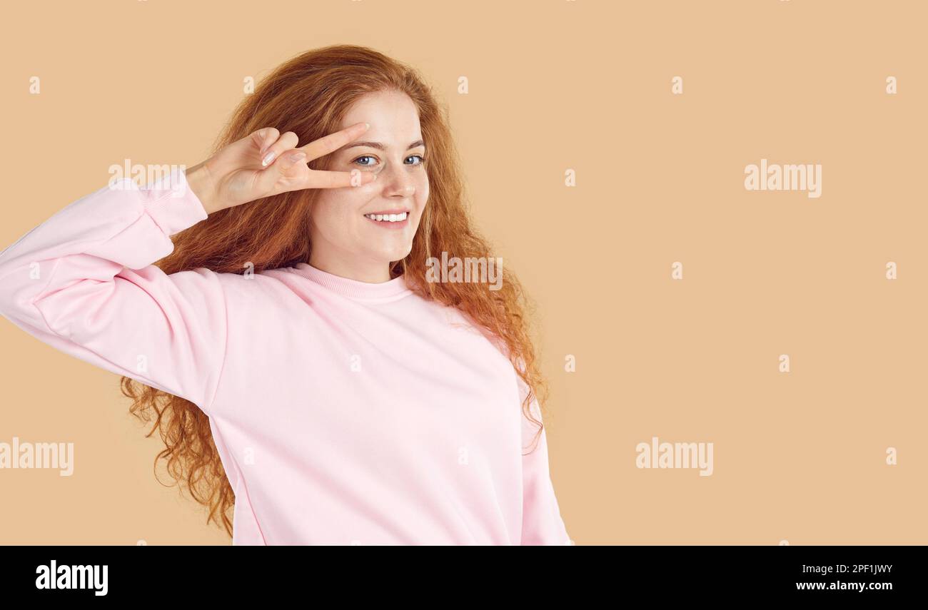 Portrait Of Cute Caucasian Teenage Girl Making Peace Gesture Showing V