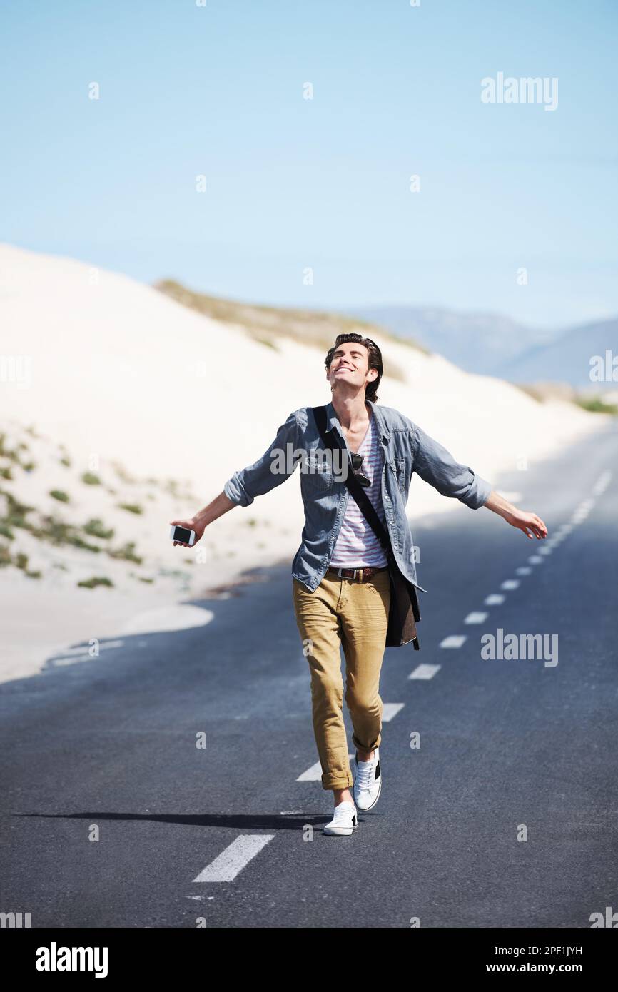 The freedom of the open road. Handsome young man with his arms ...