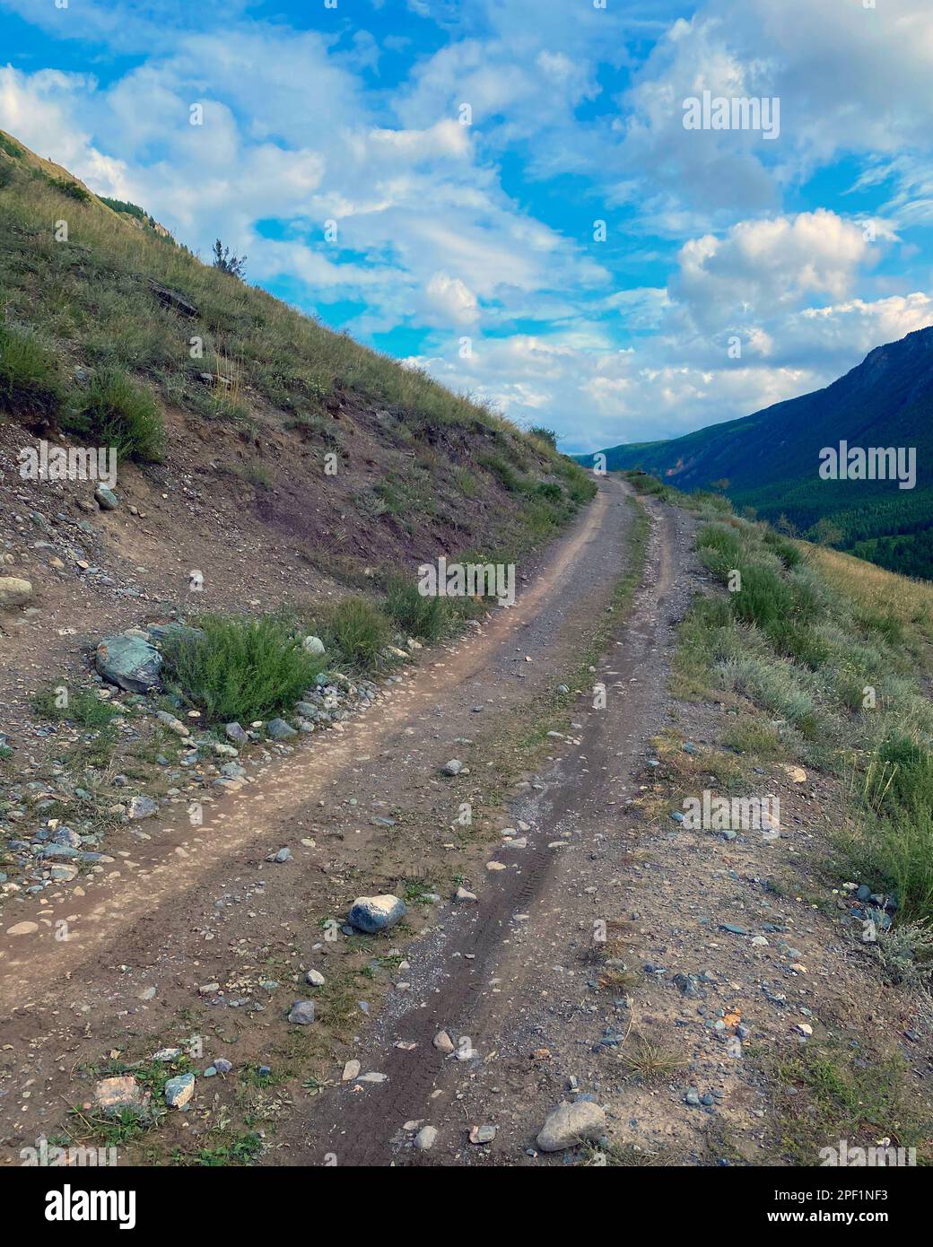 The road on the edge of the hill at the cliff goes behind the mountain ...