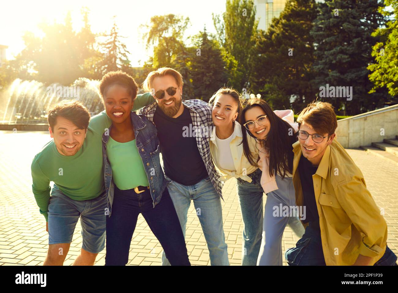 Cheerful positive young friends posing for a group photo in a summer ...