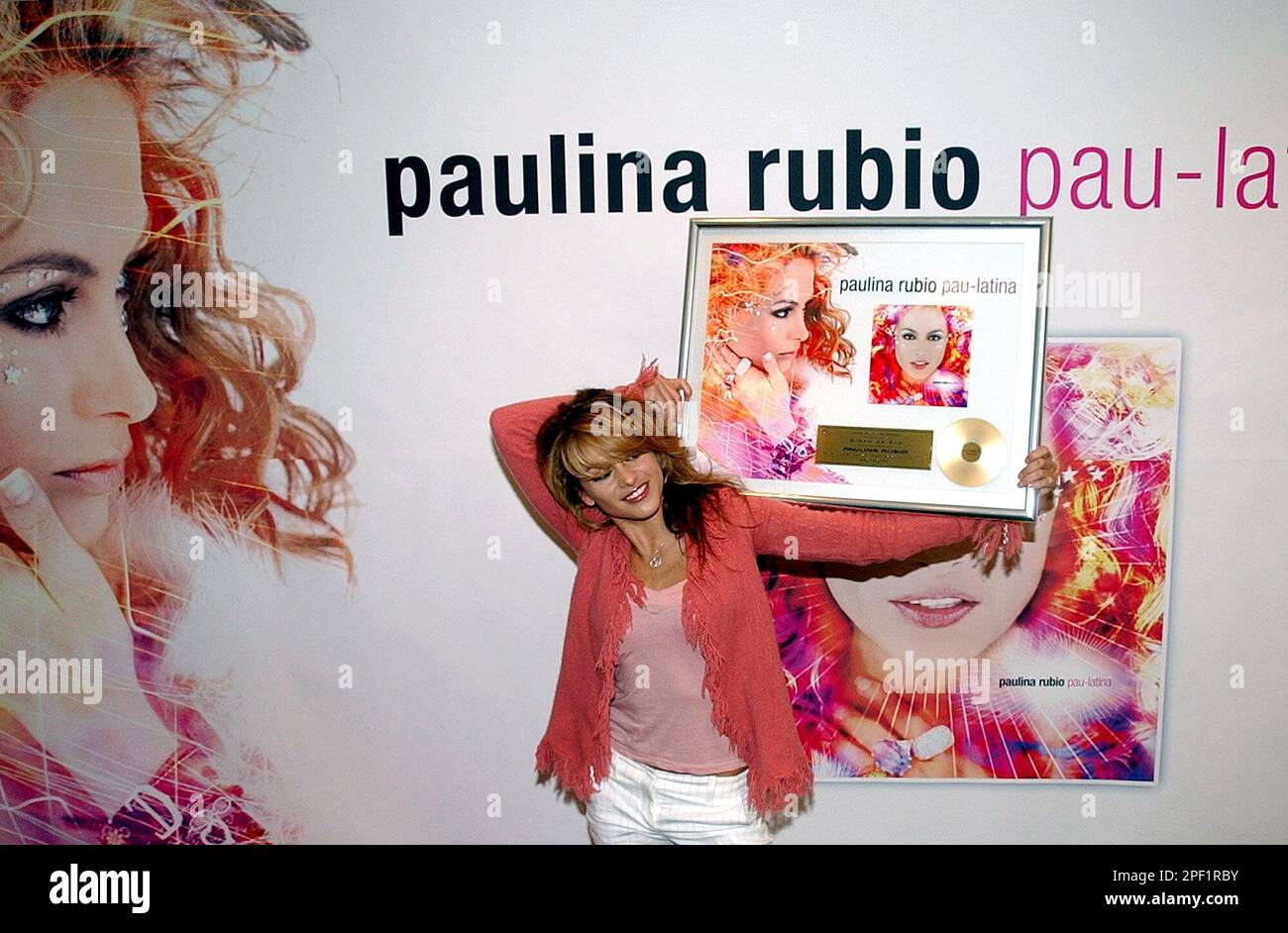 Mexican singer Paulina Rubio holds a frame of the cover art of her ...