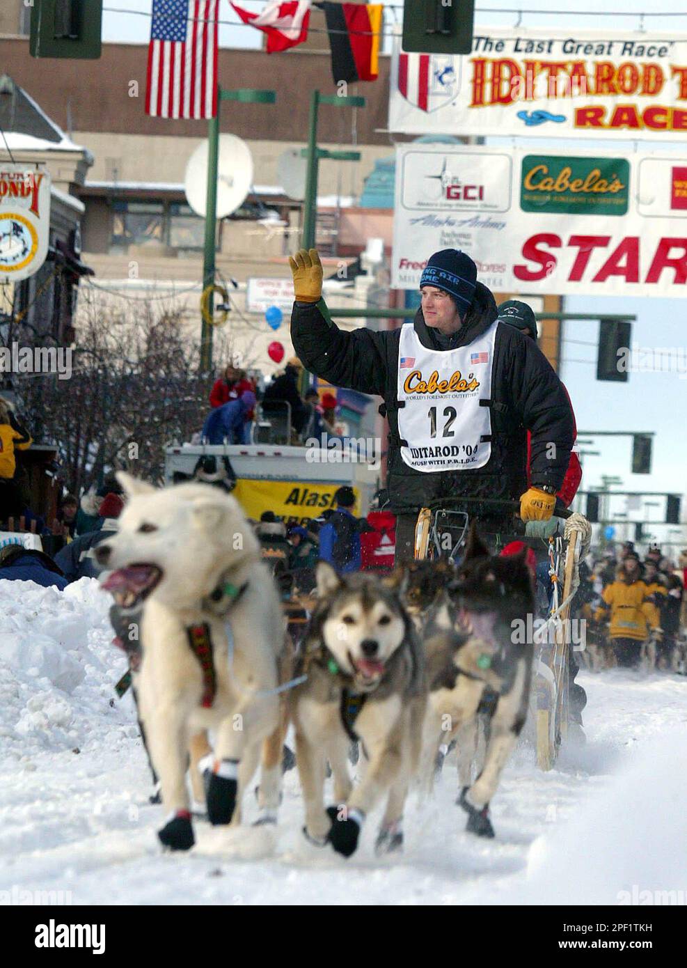 Nils Hahn of Germany waves to the crowd as he drives his dog team down ...