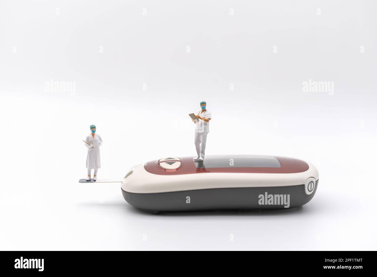 Two doctor miniature figure with patient file standing on glucose meter ...