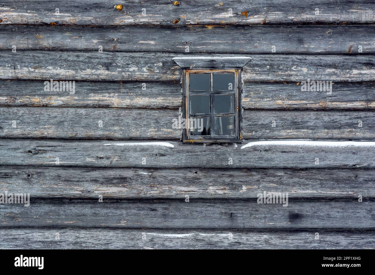 Small rectangular window against a wall of old, grayed logs. From the ...
