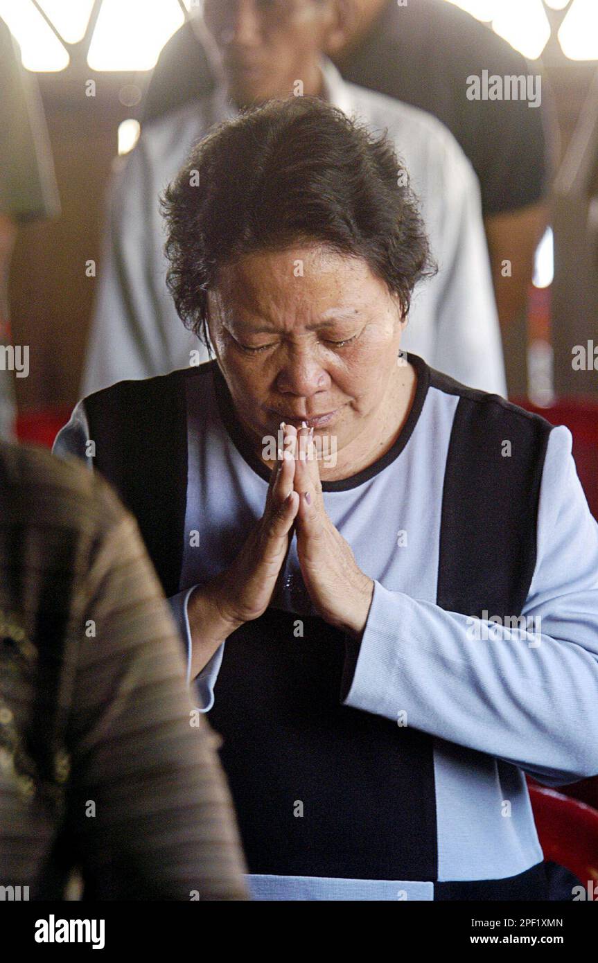 A Cambodian woman bows her head in prayer, Jan 18, 2004, at the Four ...