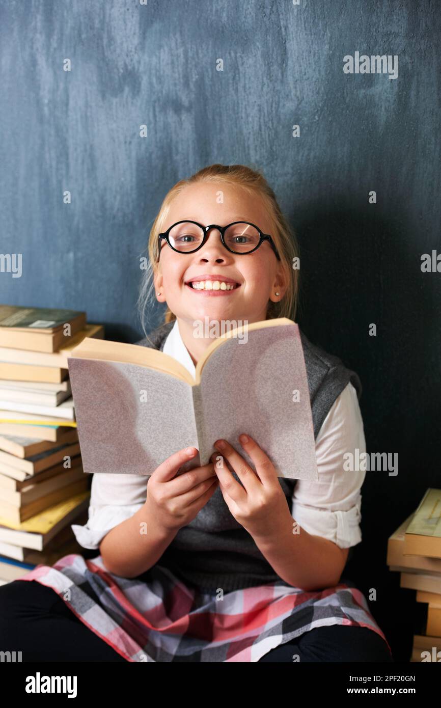 She always make time to read. A happy blonde girl studying in class ...