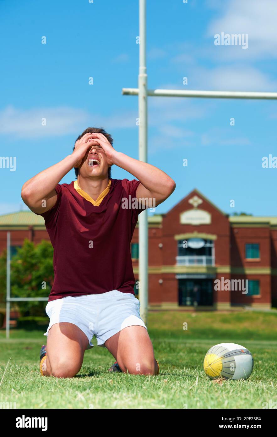 Its a mans sport. Full length shot of a young rugby player falling to ...