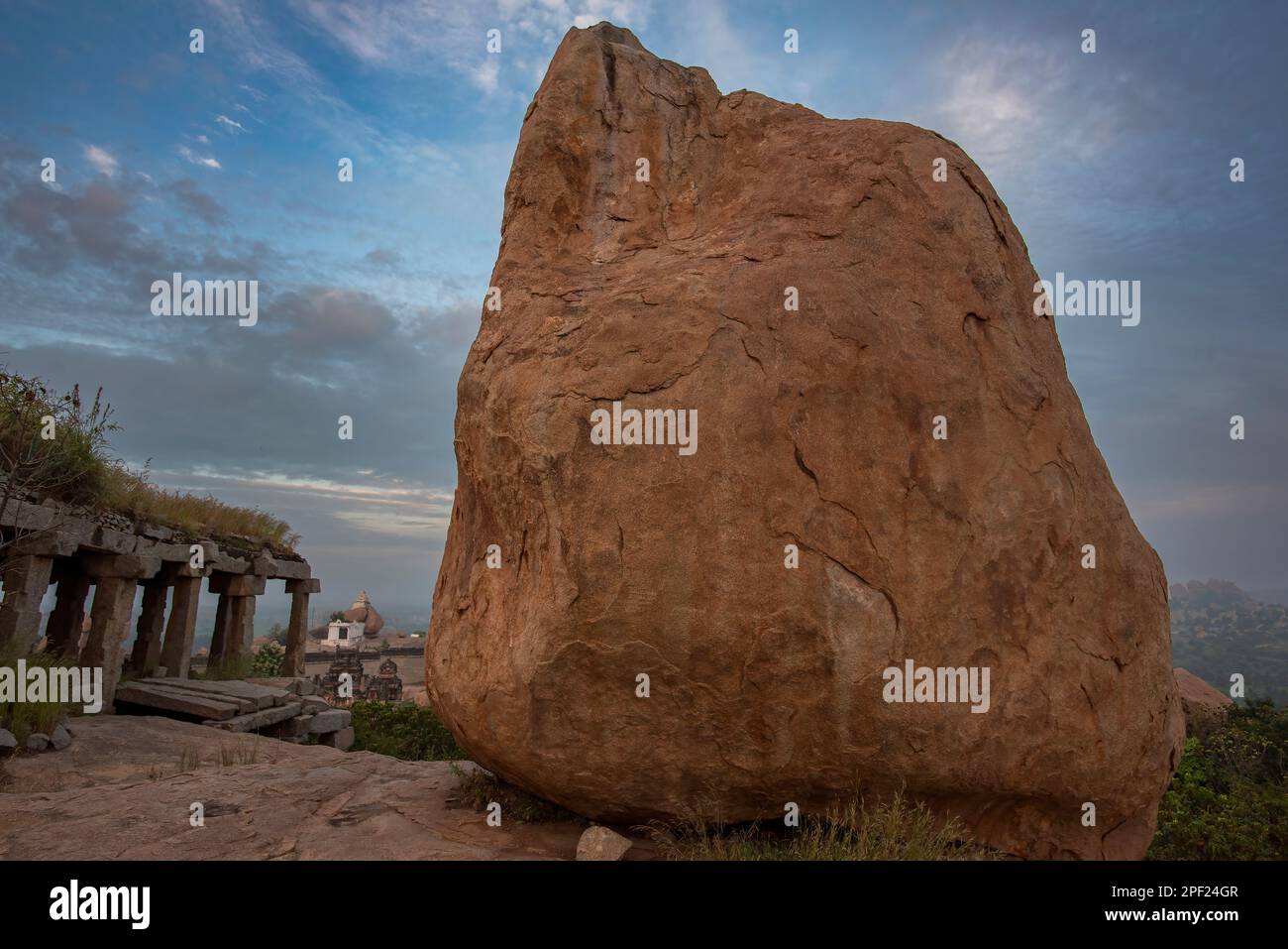 Huge boulder on Malyavanta Hill with Shiva temple in the background in Hampi. Hampi, the capital ...