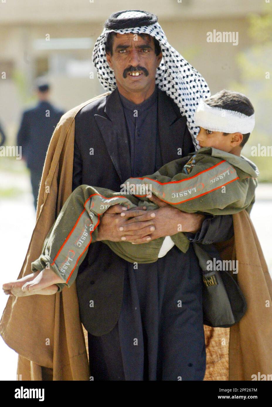 An unidentified Iraqi father carries his son for treatment at Samawa ...
