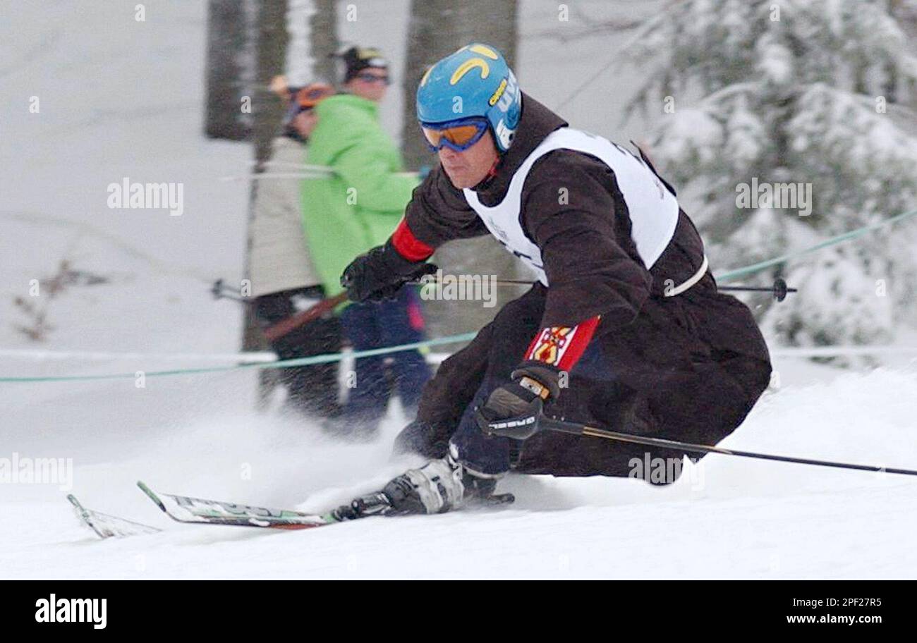 Father Dobroslaw Mezyk dressed in a robe, speeds down the slope during ...
