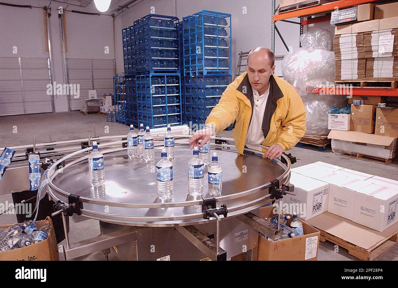 Howard Brand III, owner of Happy Water Co., reaches for a one-liter ...
