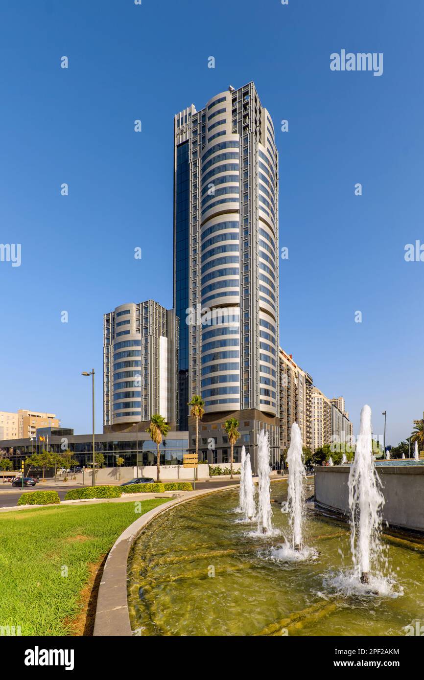 A tall building with a hotel and offices with curved facades with metal ...