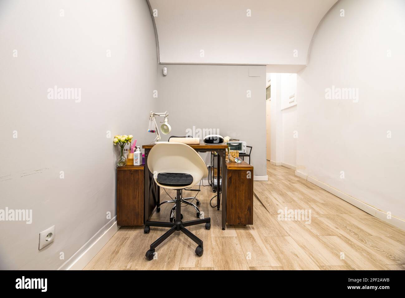Wooden table of a beauty salon dedicated to nail treatment with swivel ...