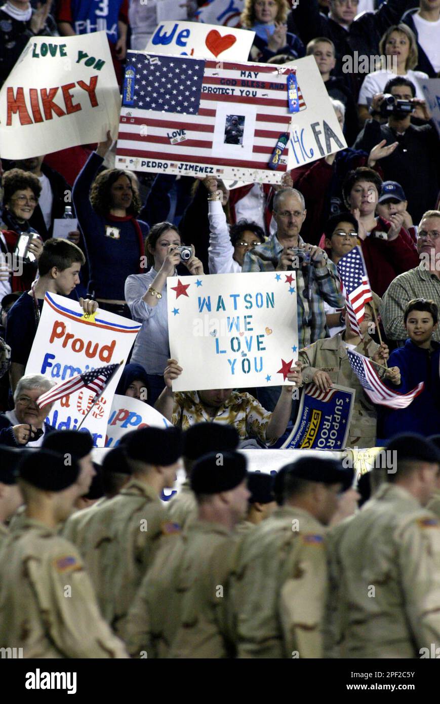 Family members waves flags and signs as soldiers of the 81st Armored ...