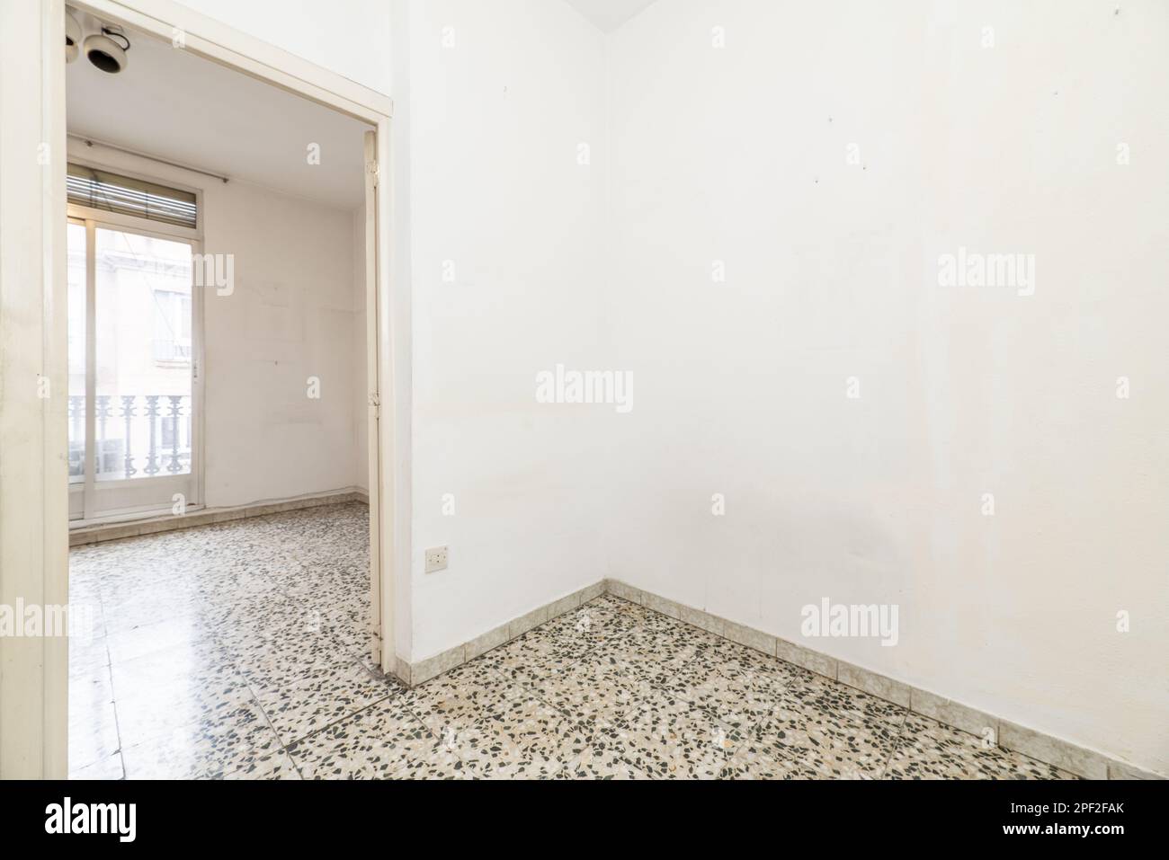 Small empty room of a house with terrazzo floors with black dots and ...