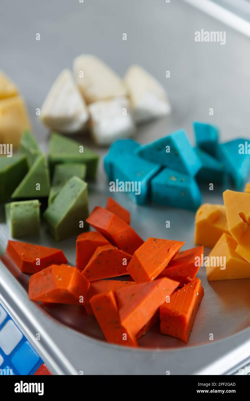 Colored cheese assortment on weighs. Pieces of multi colored dairy ...