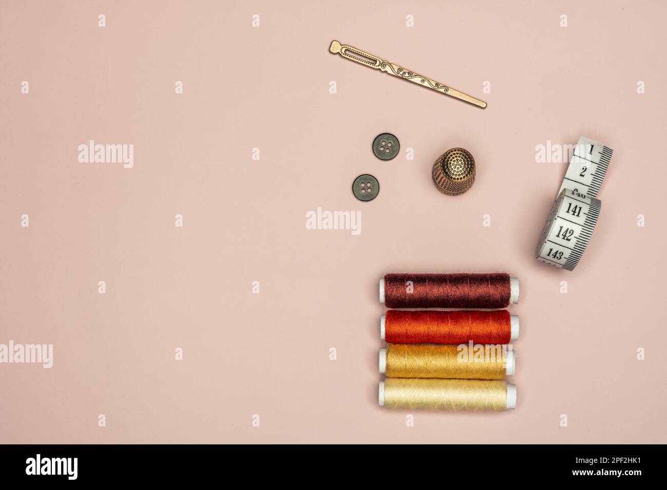 A still life with colored threads with a copper thimble with a tape ...