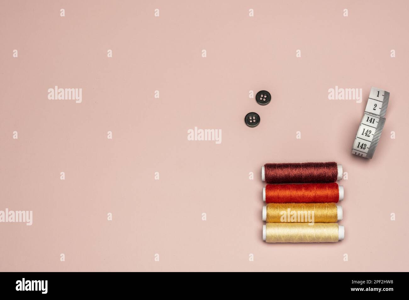 Still life with colored threads with black buttons and tape measure on ...