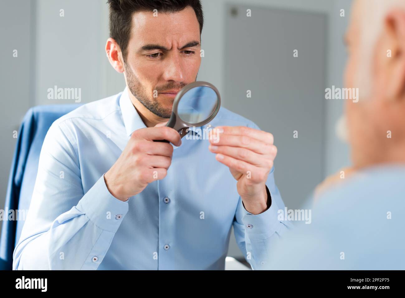 man holding a magnifying glass with a ring Stock Photo - Alamy