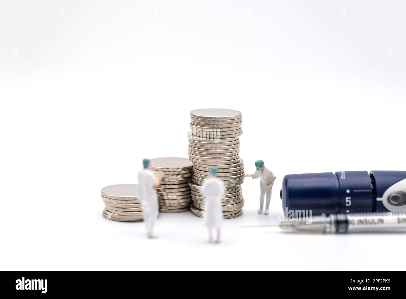 Doctor miniature figure with patient file standing with stack of coins ...