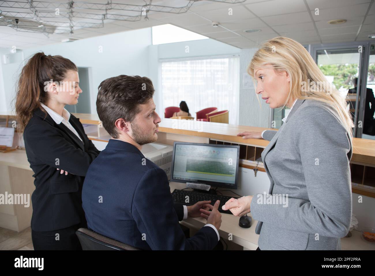 manager talking to concierge and receptionist in a hotel Stock Photo ...
