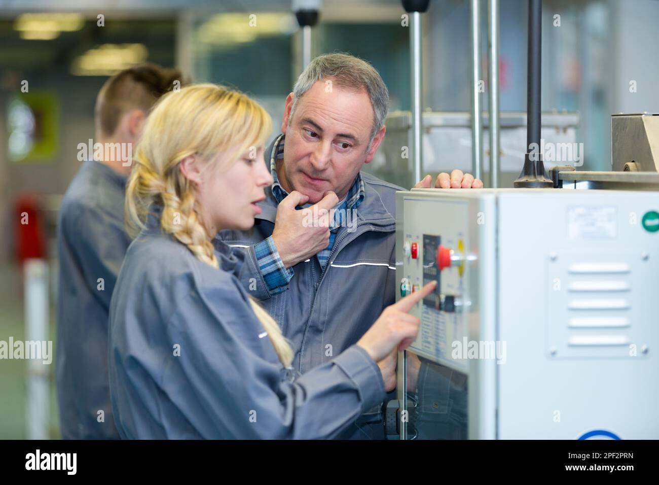 engineer and apprentice using computerized cutting machine Stock Photo ...