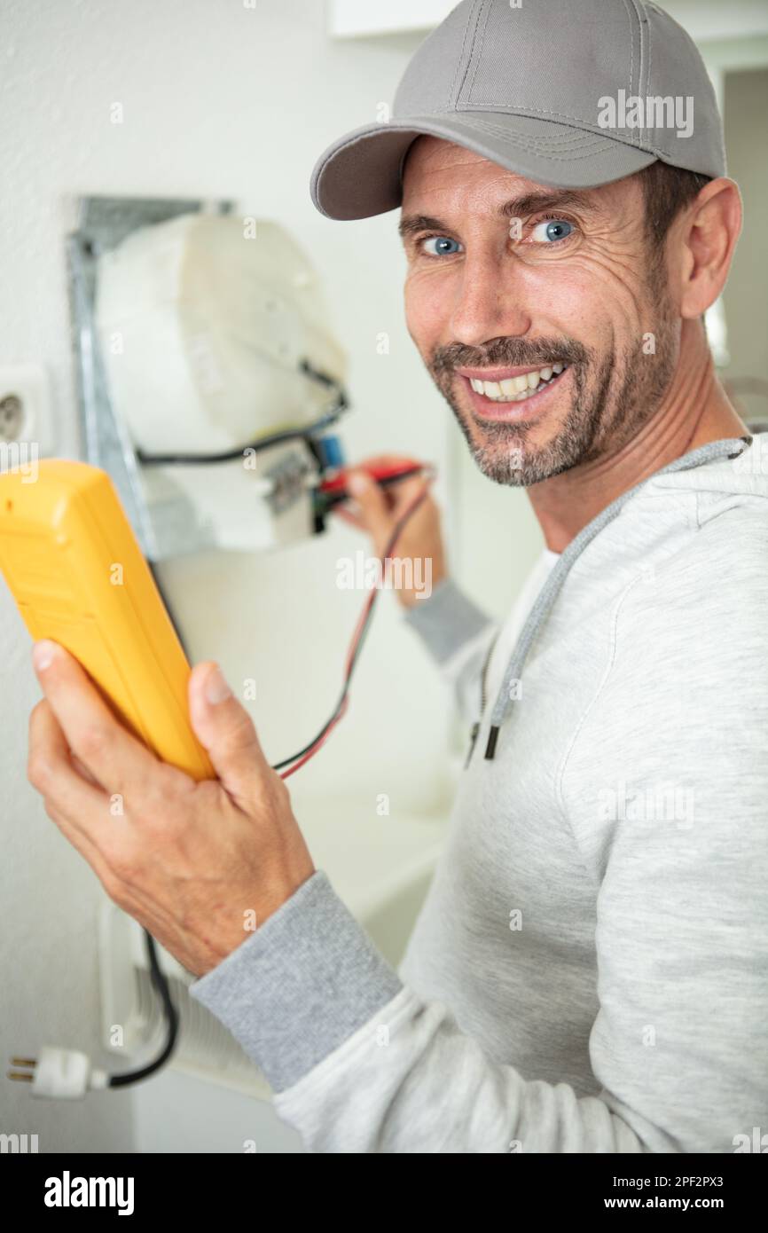 male electrician checking device with digital multimeter Stock Photo ...