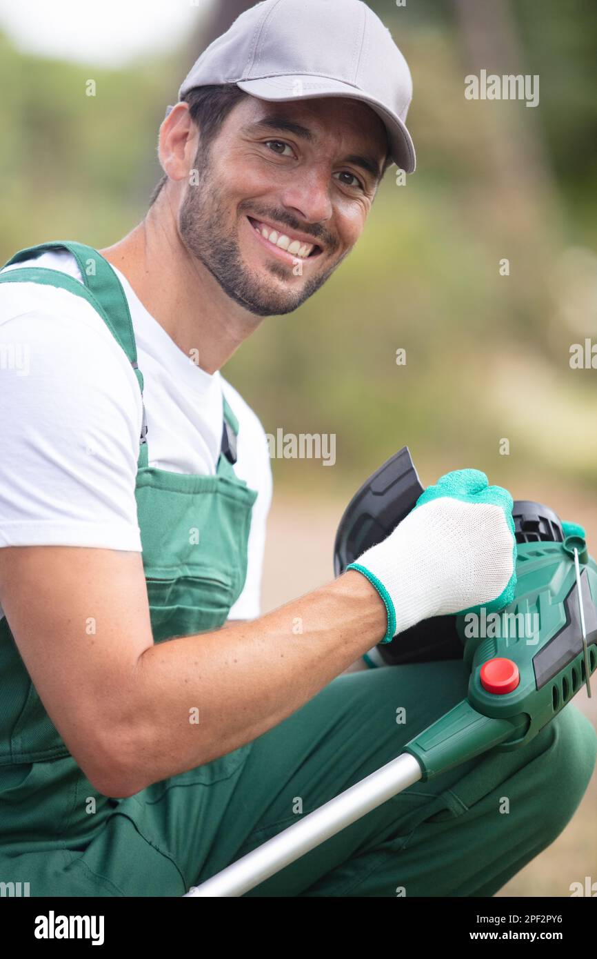 happy professional male gardener with professional garden equipment ...