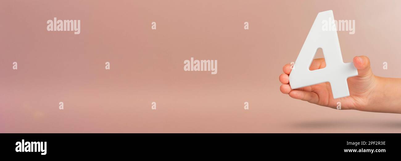 number four in hand. Hand holding white number 4 on red background with ...